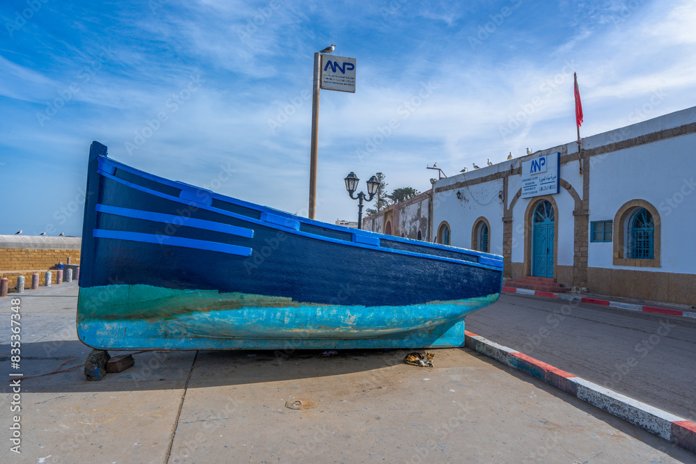 Bright blue boats on land with the ANP building in the background ...
