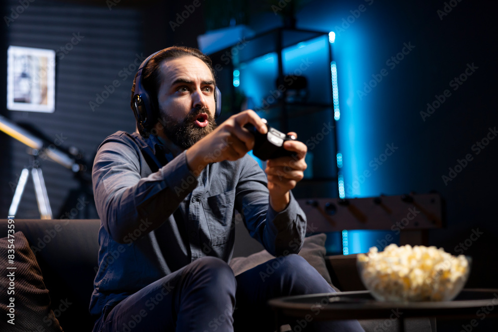 Man showing surprise facial expression while playing videogames on ...