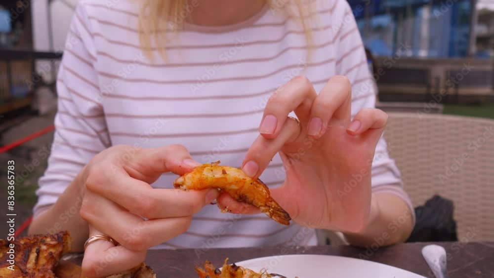 Process of peeling shrimp shells by hand. Woman peeling grilled shrimp ...