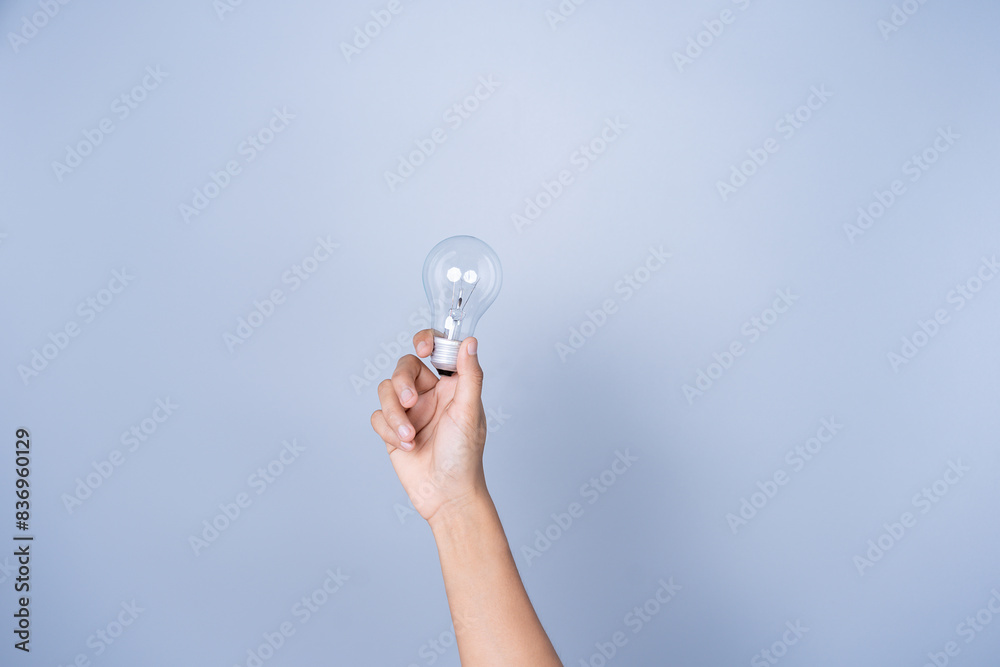 Young woman's hand holding an electric LED light bulb Innovation in ...