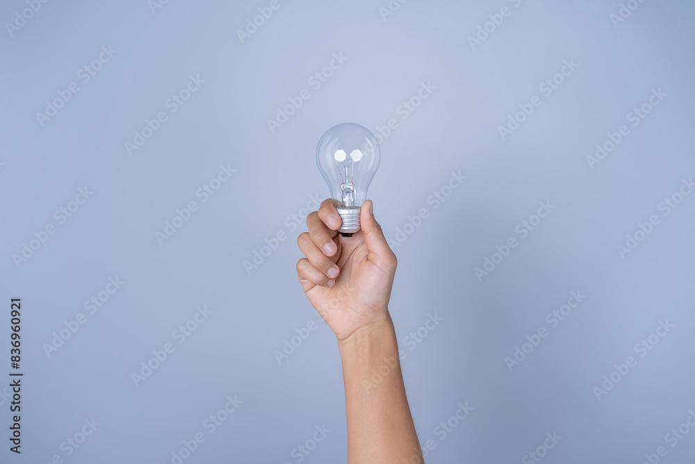 Young woman's hand holding an electric LED light bulb Innovation in ...