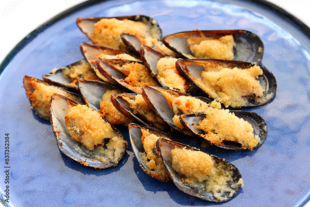 Plate of mussels au gratin. Mussels covered in wine and stuffed with ...