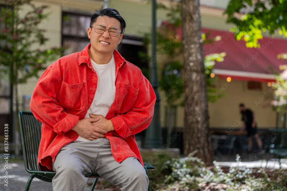 Asian middle-aged man feeling sudden strong abdominal stomach ache ...