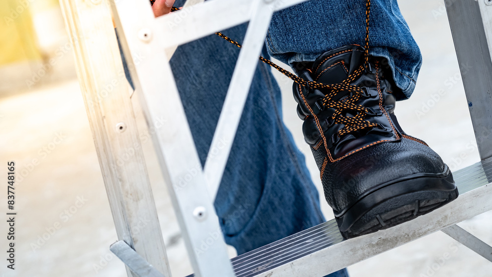 Male worker hands tying shoelaces on leather safety shoes, steps on ...