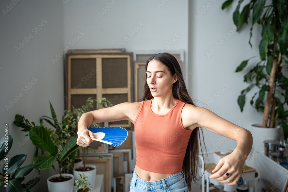 Uncomfortable woman blowing fan over sweaty armpits. Tired exhausted ...