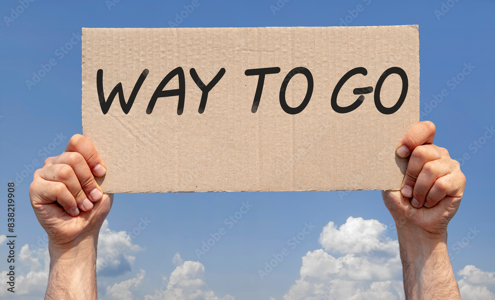 Hands holding a piece of cardboard with the inscription "way to go ...
