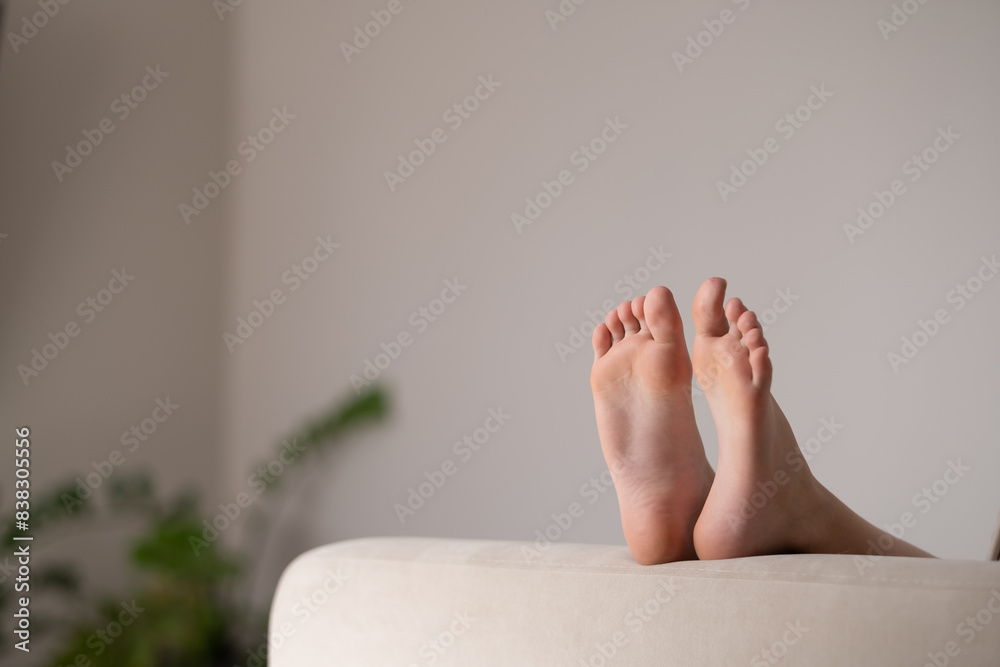 feet of a 12 year old child, legs on the sofa in a cozy home ...