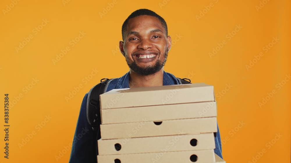 African american pizzeria deliveryman holding stack of pizza boxes to ...