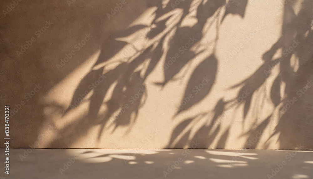 light background of shadows from plant leaves on a light brown beige ...