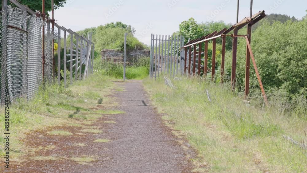 Broken, abandoned, ruined bridge path, rusty fence girders, overgrown ...