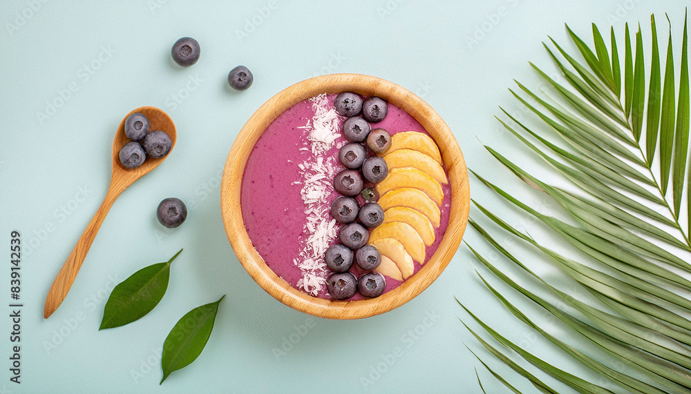 Blue background with acai bowl with fruit, coconut and a palm leaf ...