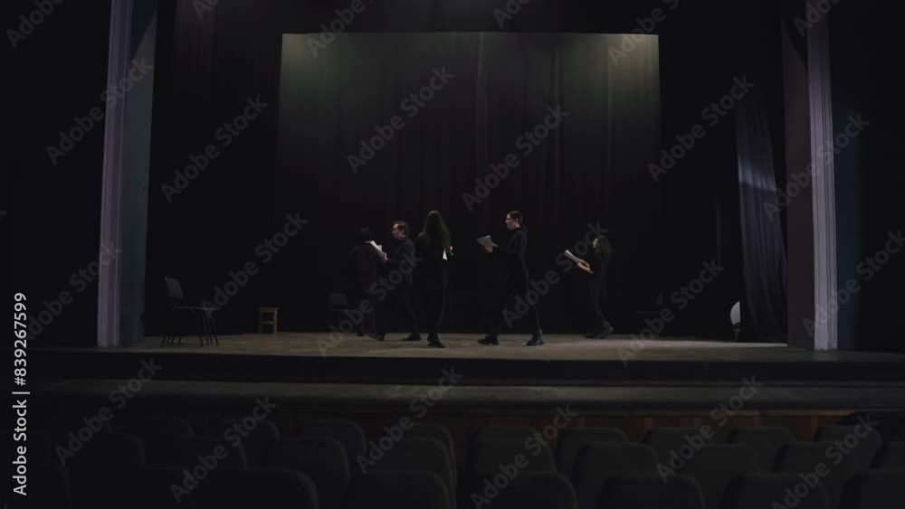 Confident group of young actors in black suits walk in a circle on ...