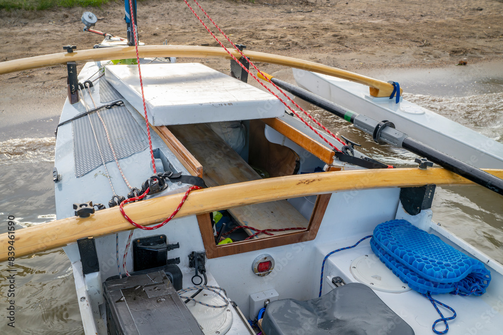 detail of a homebuilt sailing and rowing trimaran boat with a small ...