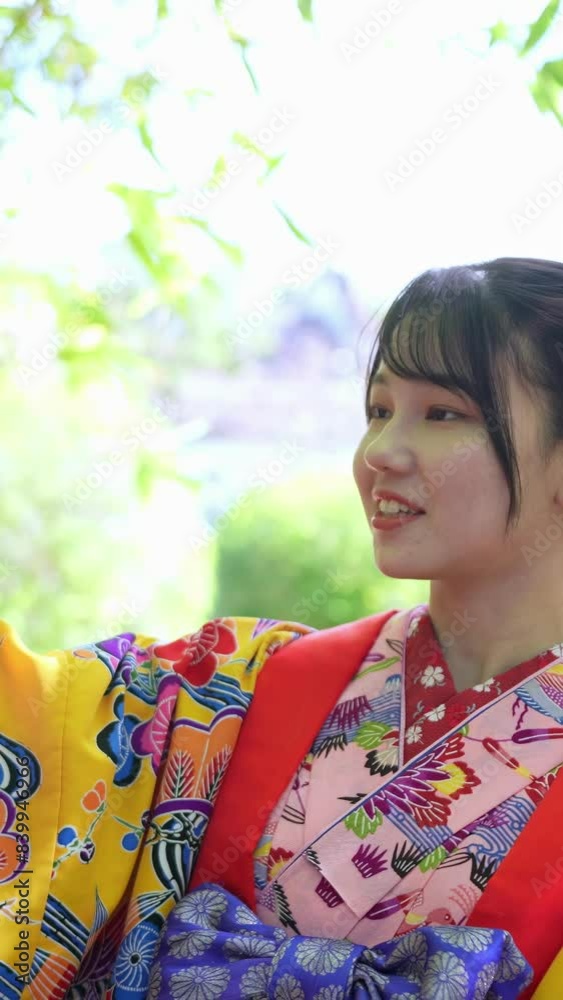 A young woman in traditional Ryuso attire captures a selfie in a ...
