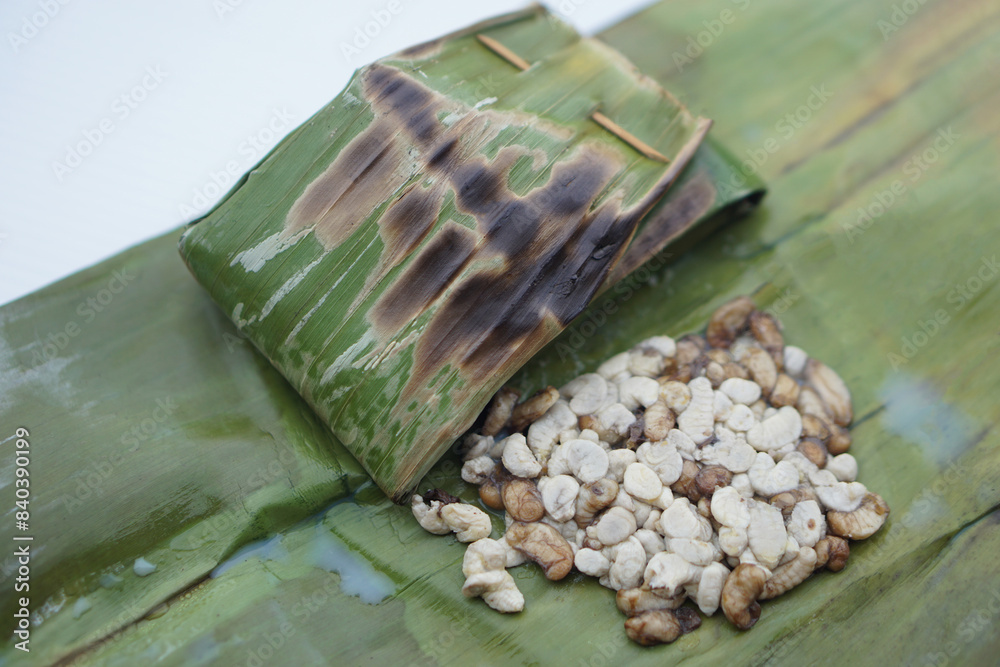 Grilled bee eggs, which wrapped by banana leaf. Concept, food from ...