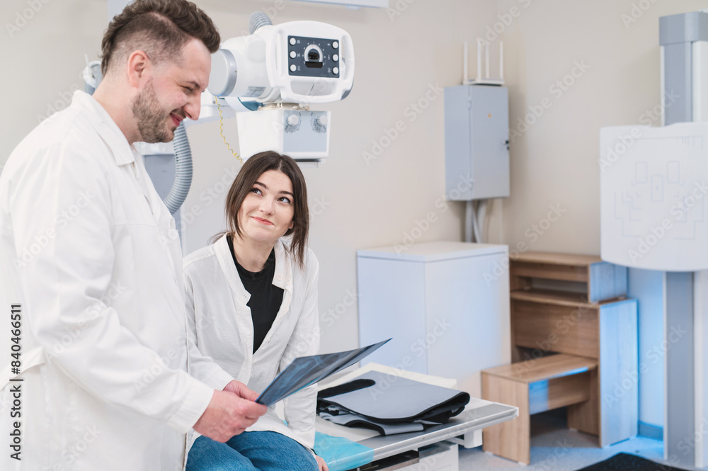 A male doctor shows xray photo to female patient to take an x-ray on a ...