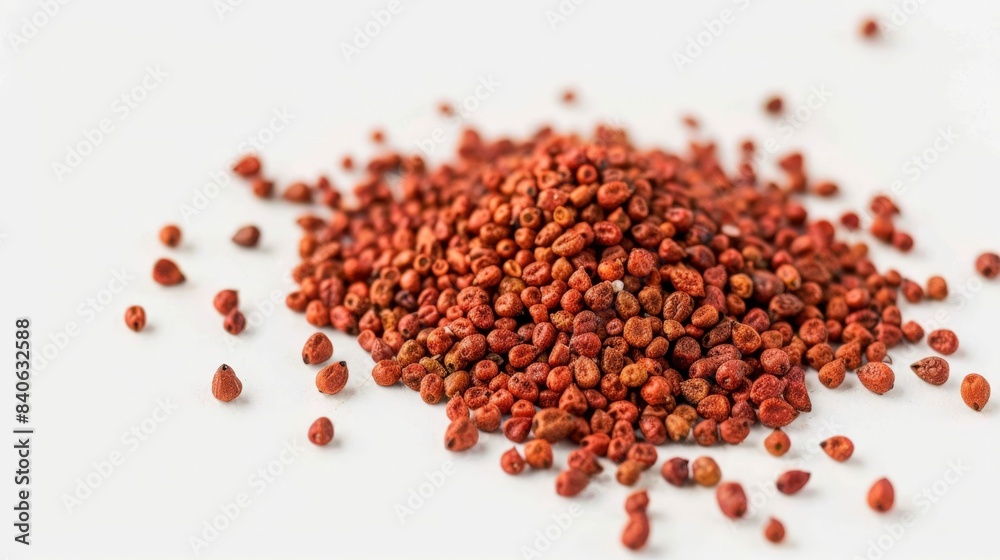 Achiote seeds scattered on white, showing their small size and intense ...