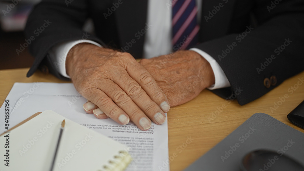 Elderly man with hands on documents at an office desk, showcasing ...
