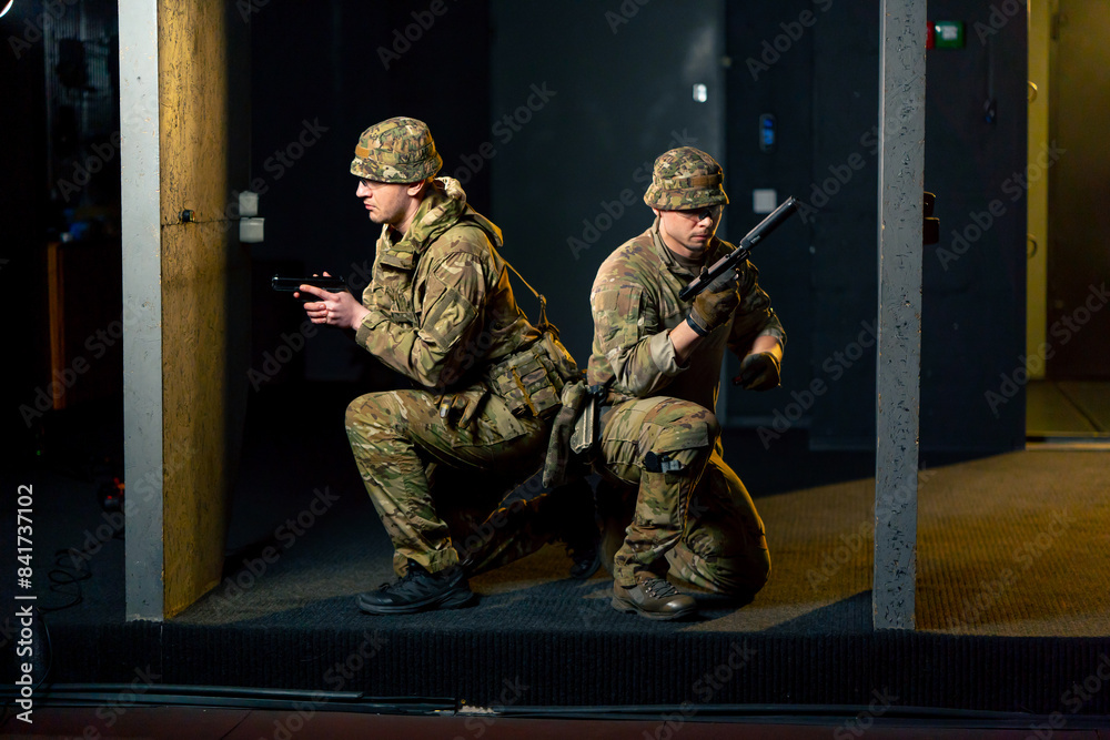 At a professional shooting range two military trainers perform tactical ...