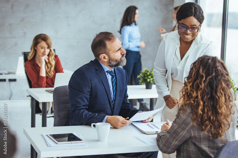 A diverse group of professionals collaborates around a table ...