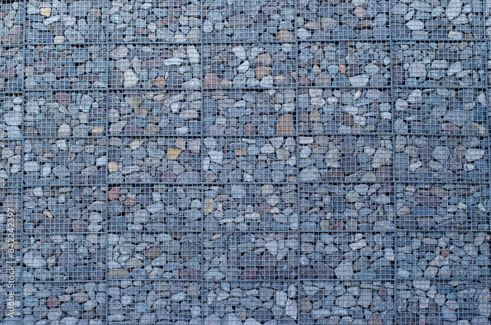 Background texture of a gabion wall made of wire mesh filled with ...