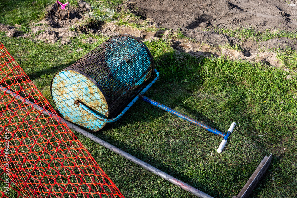 Old metal blue drum roller and rake, grass pasture invasive plant ...