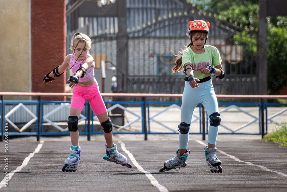 Cute smiling girl in roller skates and helmet in stadium. Pretty child ...