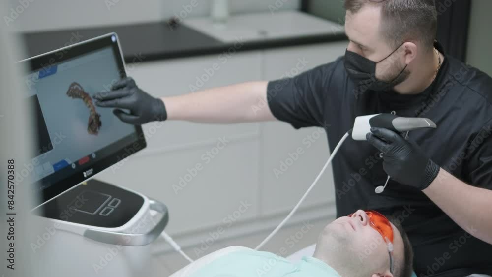 Doctor scans the patient's teeth in the clinic. The dentist holds in ...