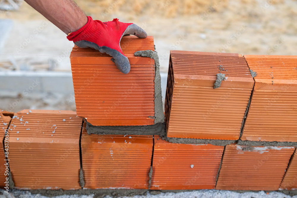 Worker builds a brick wall for house construction. Worker building a ...