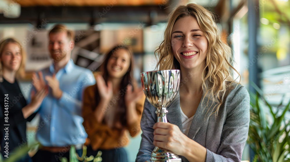 Businesswoman in suit holding a golden trophy cup with both hands ...