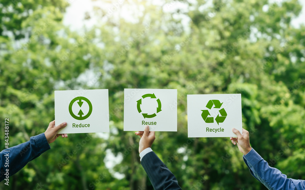 Business team holding a sign recycle reuse reduce on nature background ...