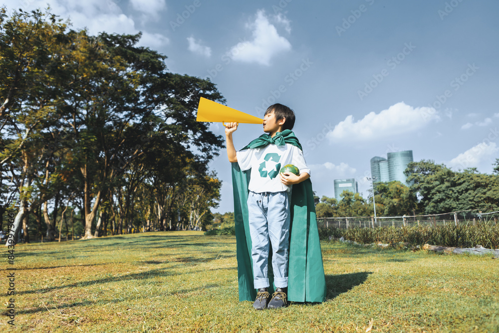 Young superhero boy with recycle symbol and cape make announcement with ...