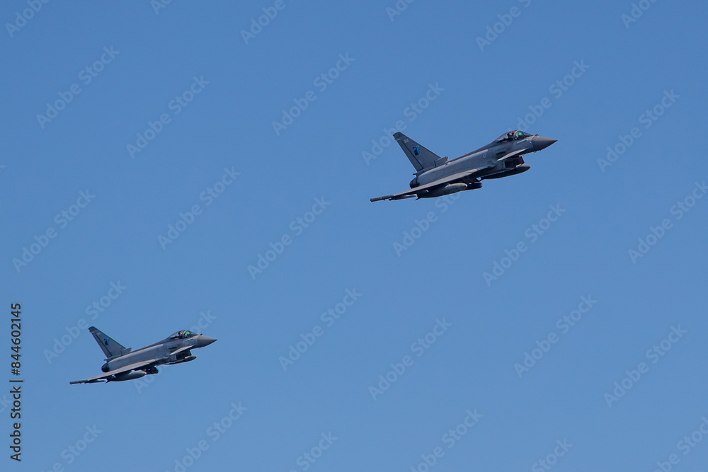 Two Typhoon Eurofighter jets flying over town centre with missiles on ...