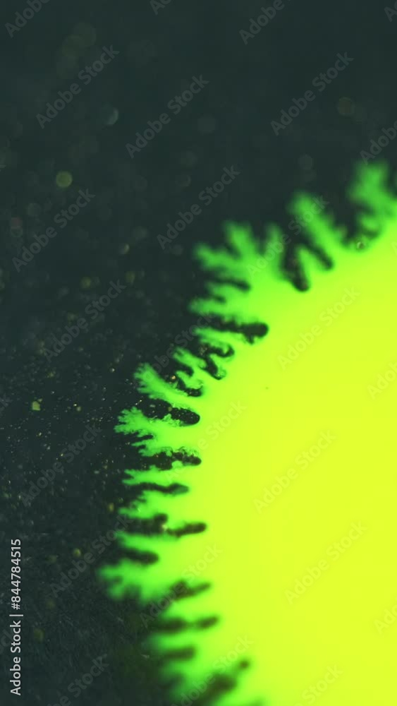 Vertical video. Ink drop. Paint splatter. Defocused neon yellow green ...