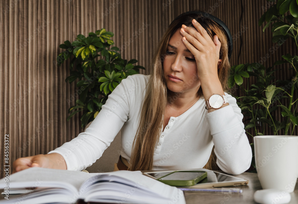 Stressed woman at work, holding head in frustration while reading ...