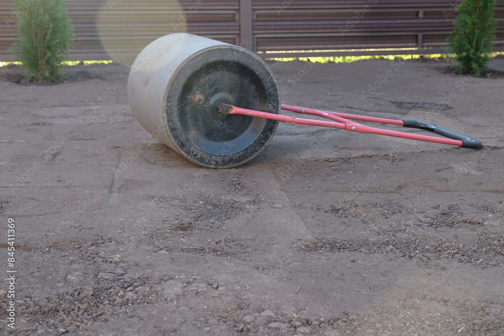 Garden roller close-up, preparing the soil for sowing lawn grass ...