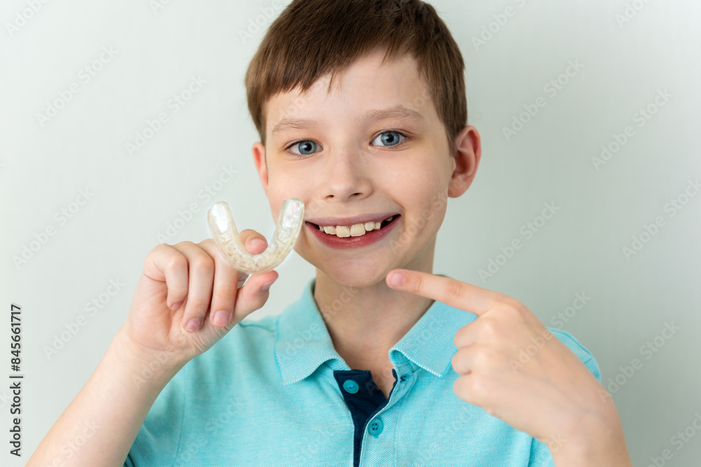 Cute positive child boy holding invisible aligners for whitening and ...