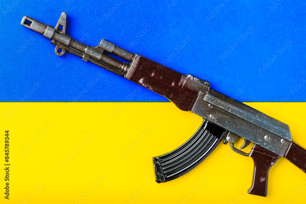 Toy gun is on the flag of Ukraine. Symbolic abstract background or ...