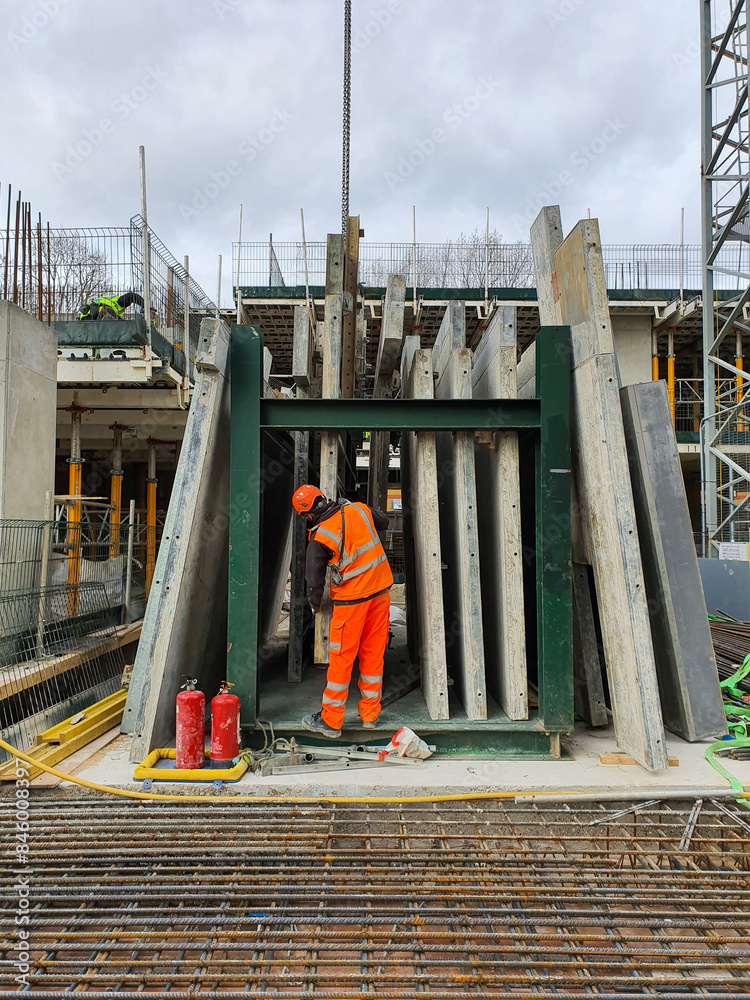 Construction worker in high visibility clothing operating tower crane ...