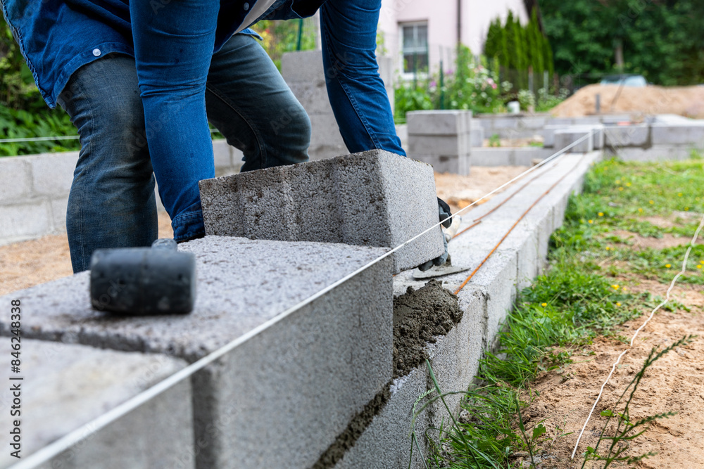 Construction worker laying expanded clay blocks. Foundations of a house ...