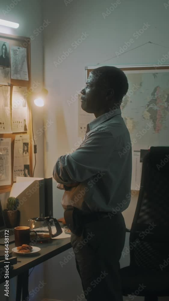 Medium vertical shot of African American police detective standing in ...