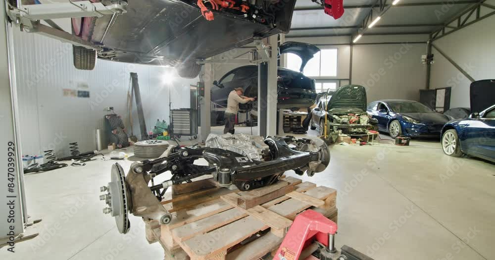 Mechanic working on repairing an electric vehicle in a modern auto ...