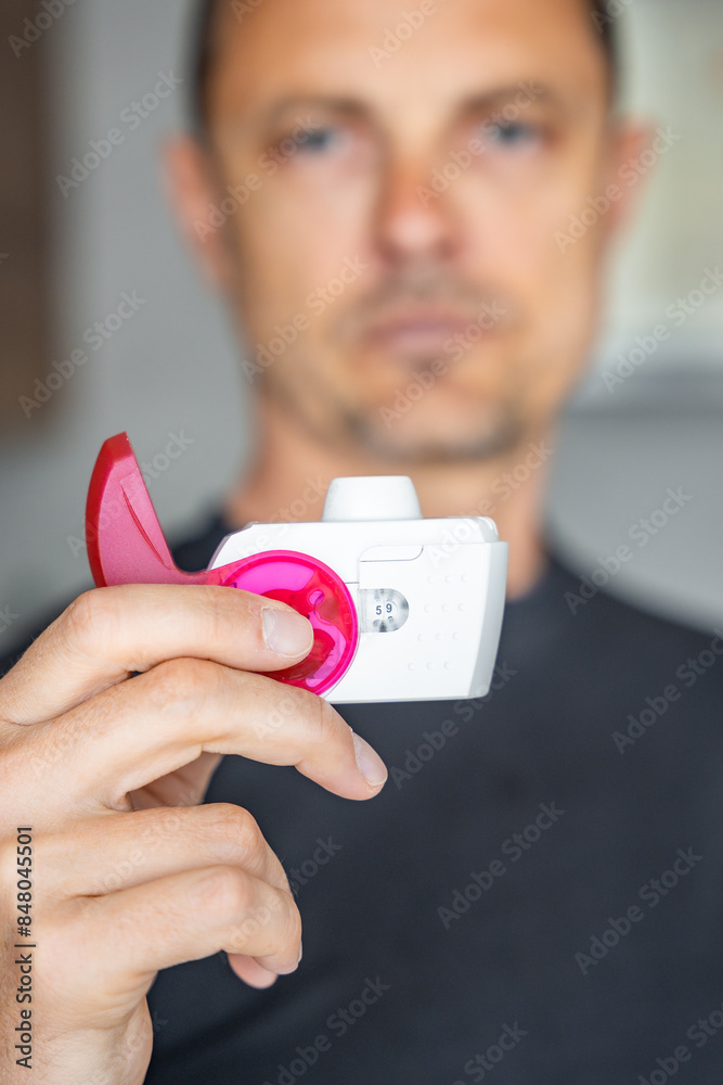 Close up view of man using medicine dry powder inhaler for treatment ...