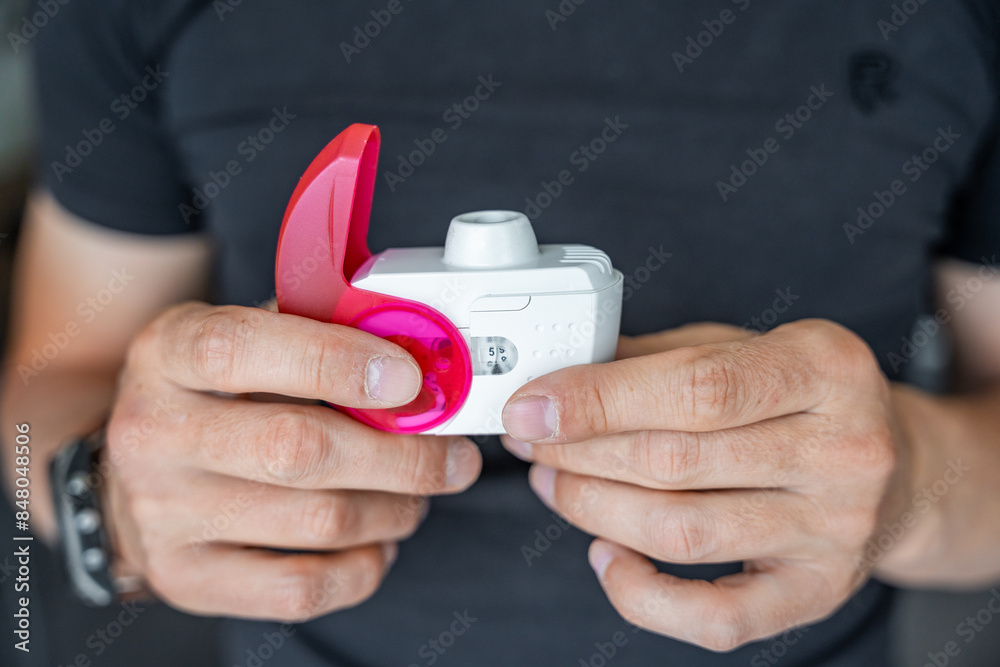 Close up view of man using medicine dry powder inhaler for treatment ...
