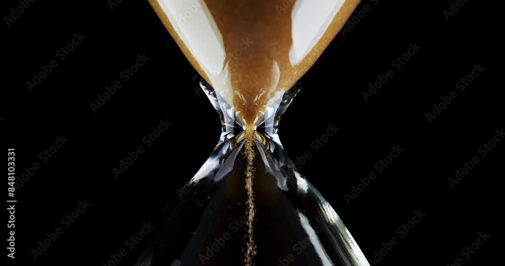 Hourglass. Sands move through hour glass. Sandglass close-up on a black ...