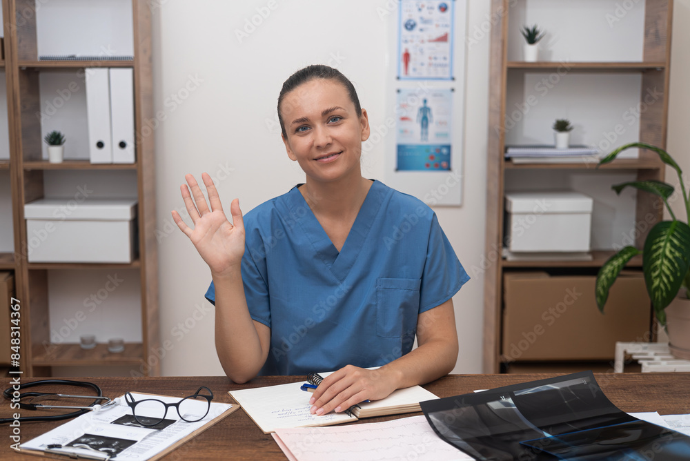 Telemedicine Greeting: A smiling female doctor in a blue lab coat ...