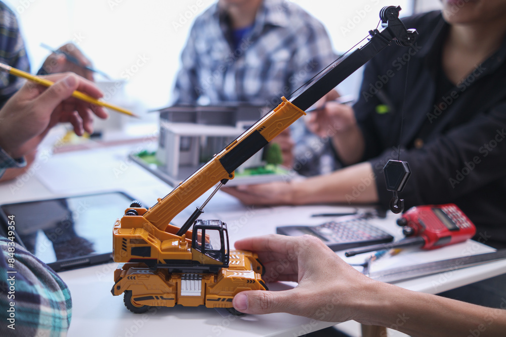 crane model sits on table of construction engineer after discussing how ...