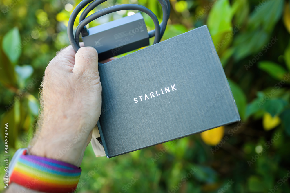 Germany - Jun 15, 2023: A hand holding a Starlink Ethernet Adapter and ...