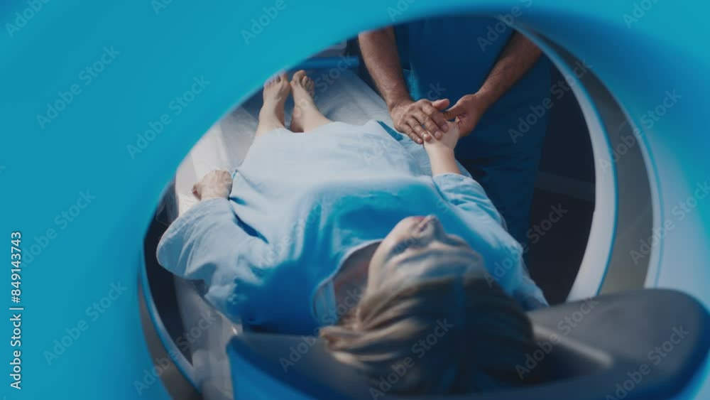 Inside view of MRI machine with female patient lying on scanner bed ...