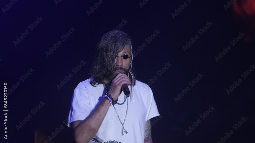 An outrageous circus presenter with long hair stands in the circus ...